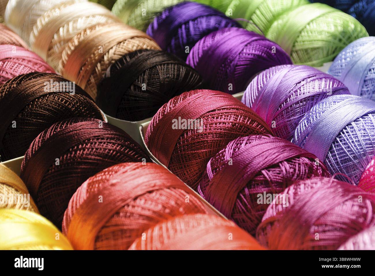 Different color threads on rows in the store Stock Photo - Alamy