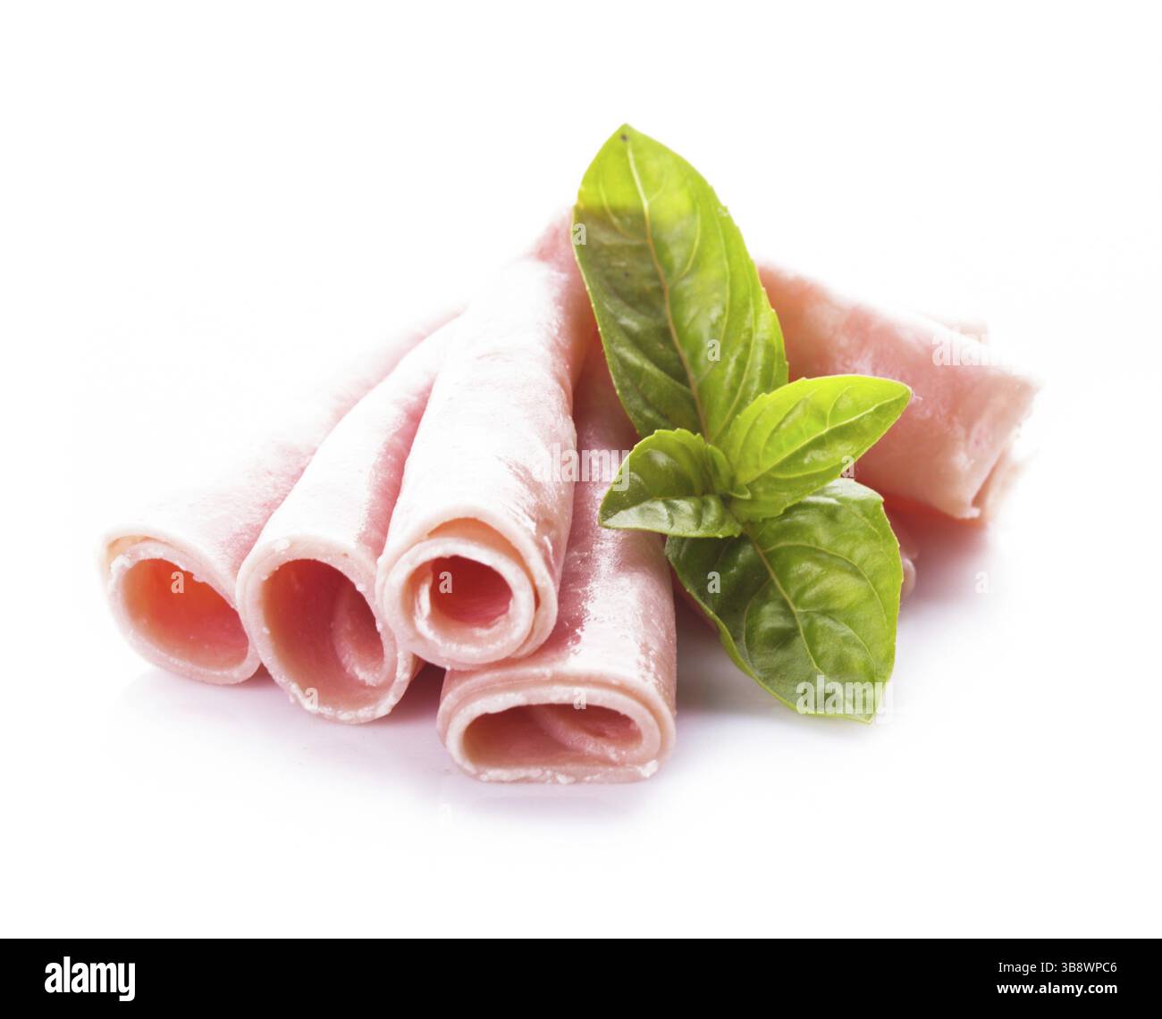 Ham slices isolated on white with green basil leaves Stock Photo - Alamy