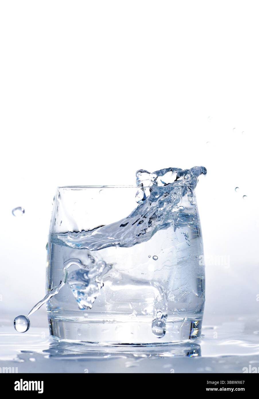 Throwed ice cube into the glass of water Stock Photo - Alamy