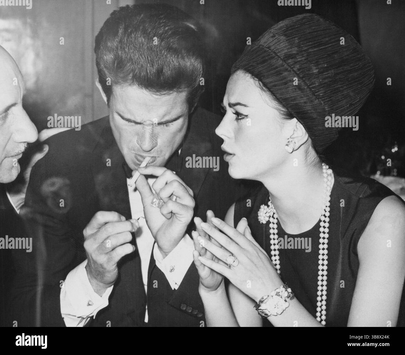American actor Warren Beatty appears to burn his fingers as he lights a ...