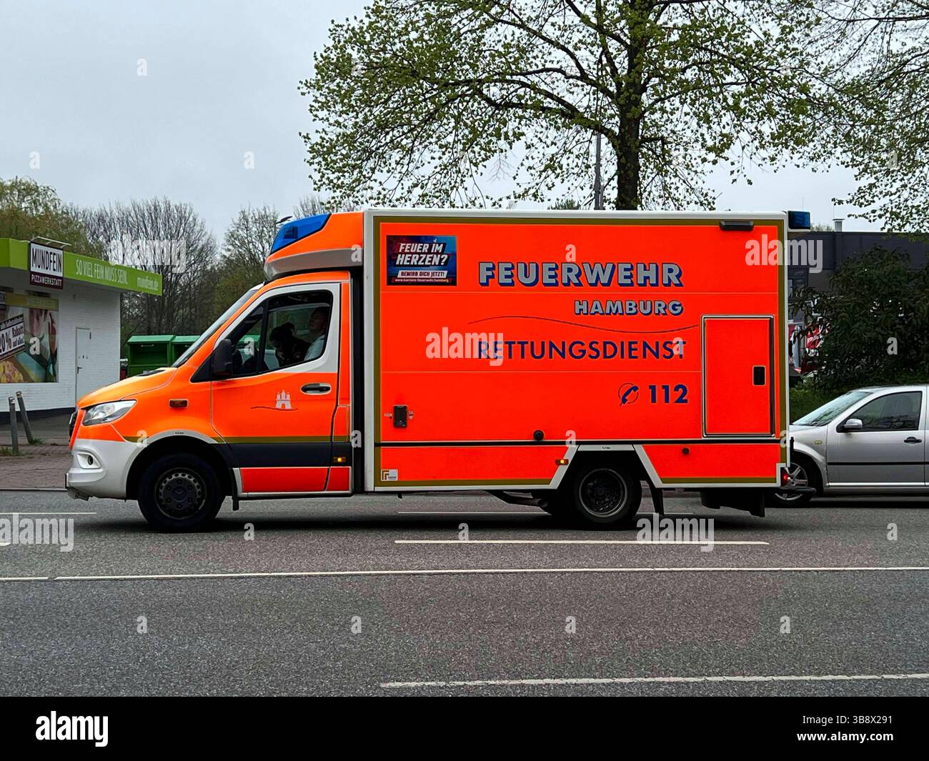 Rettungswagen RTW der Hamburger Feuerwehr in den Farben Rot Weiss auf dem Weg zum Einsatz auf ...