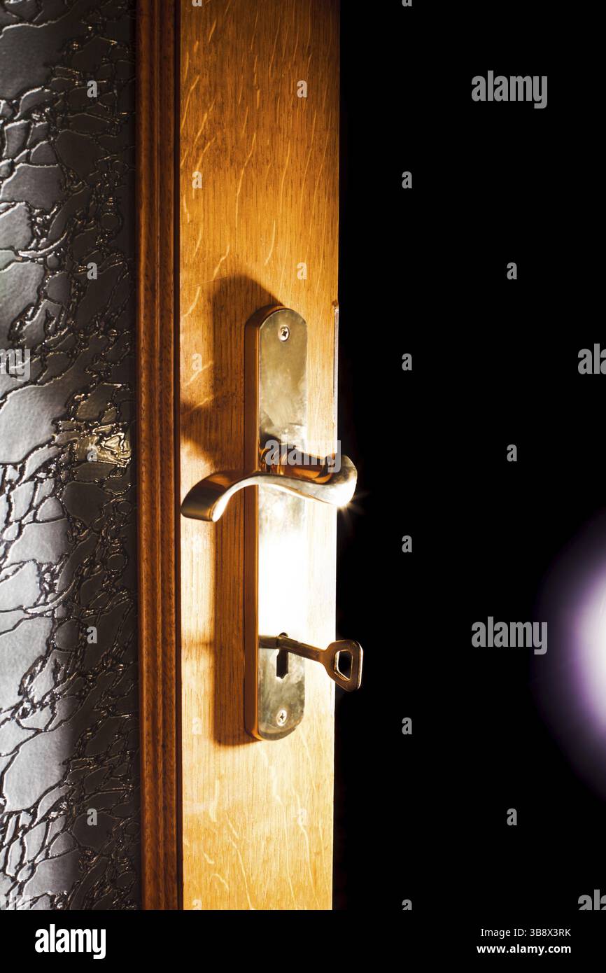 Open door with key into the dark room with light Stock Photo - Alamy