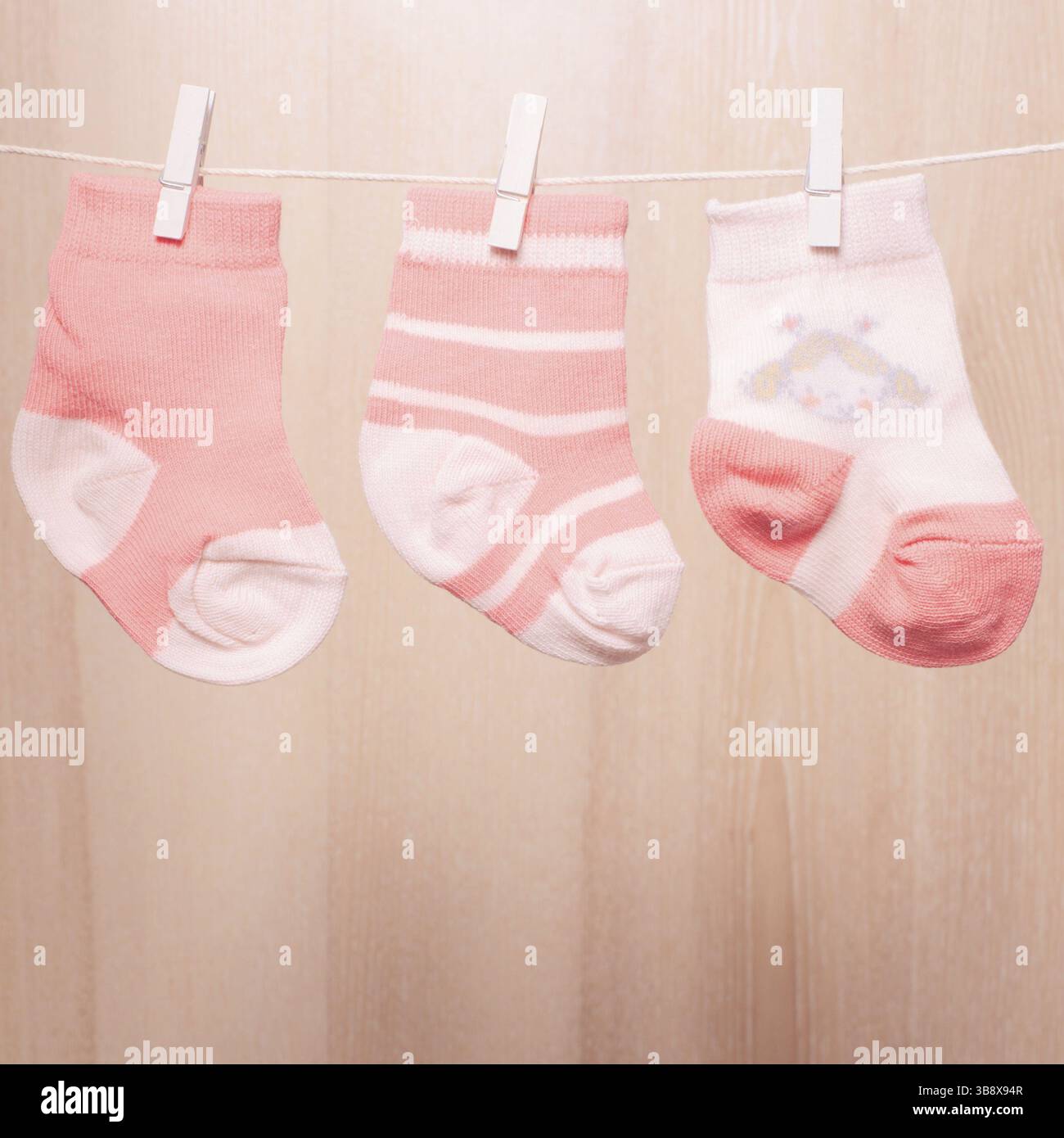 Baby girl socks attached to the rope Stock Photo - Alamy