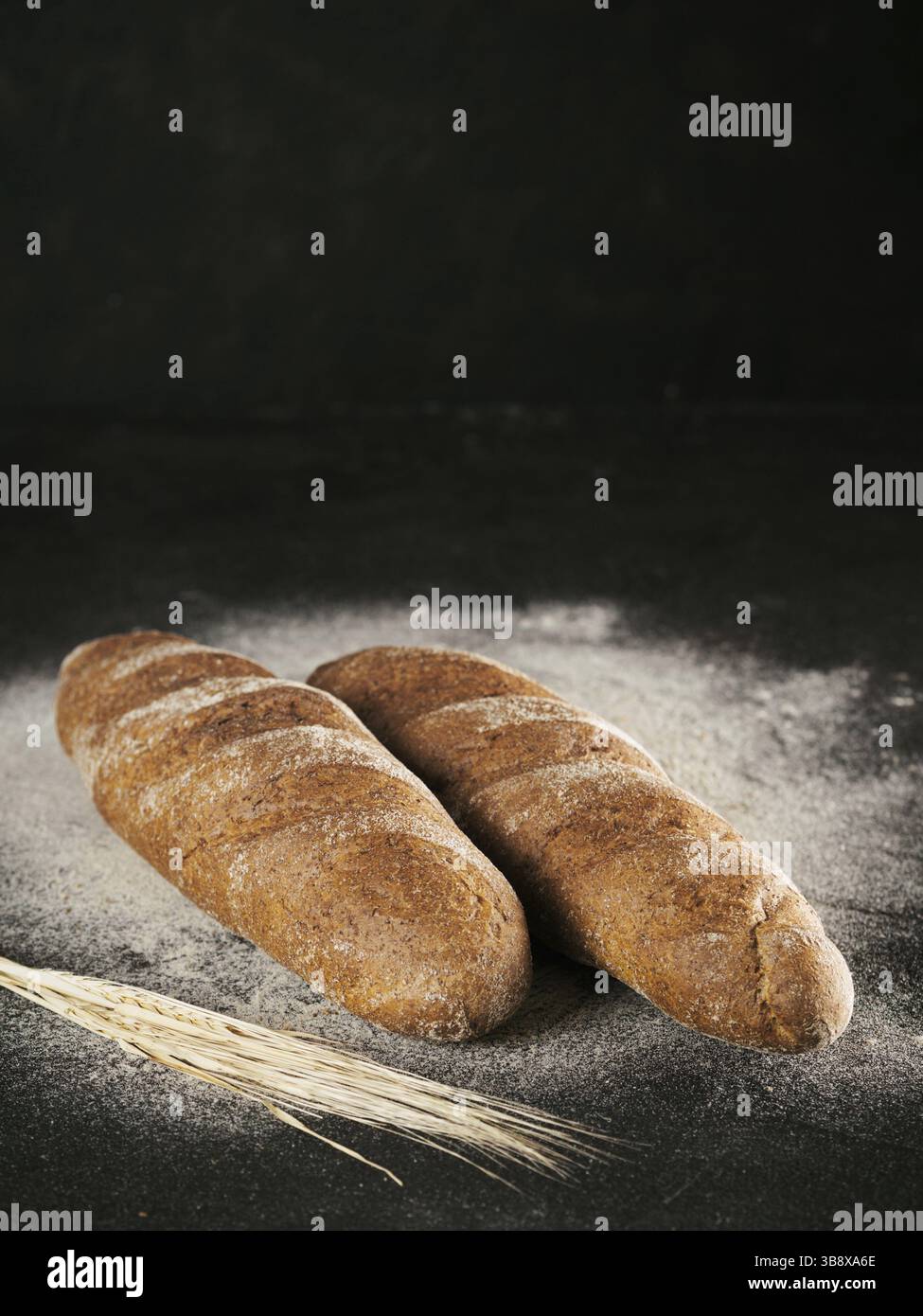 Two whole homemade rye loaf bread with buckwheat flour on black ...
