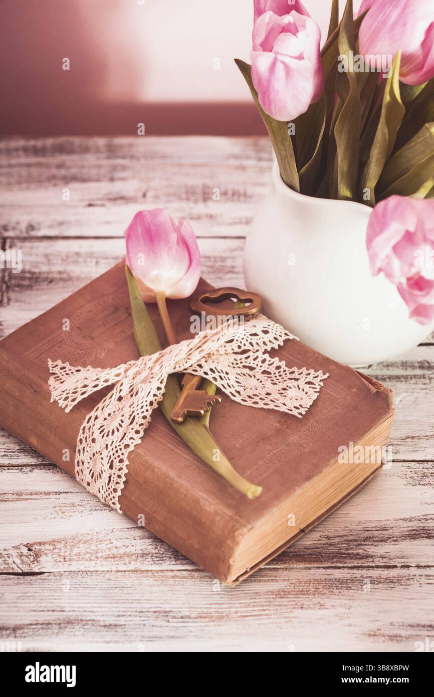 Memo still life with book, key, vintage lace and pink tulips Stock ...