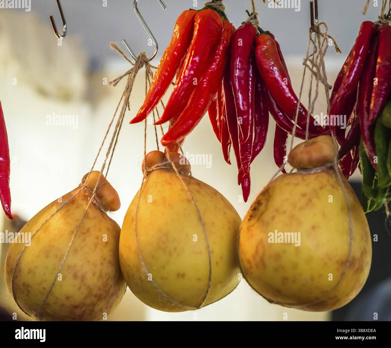 Fruits and chili pepper hanging on hooks Stock Photo - Alamy