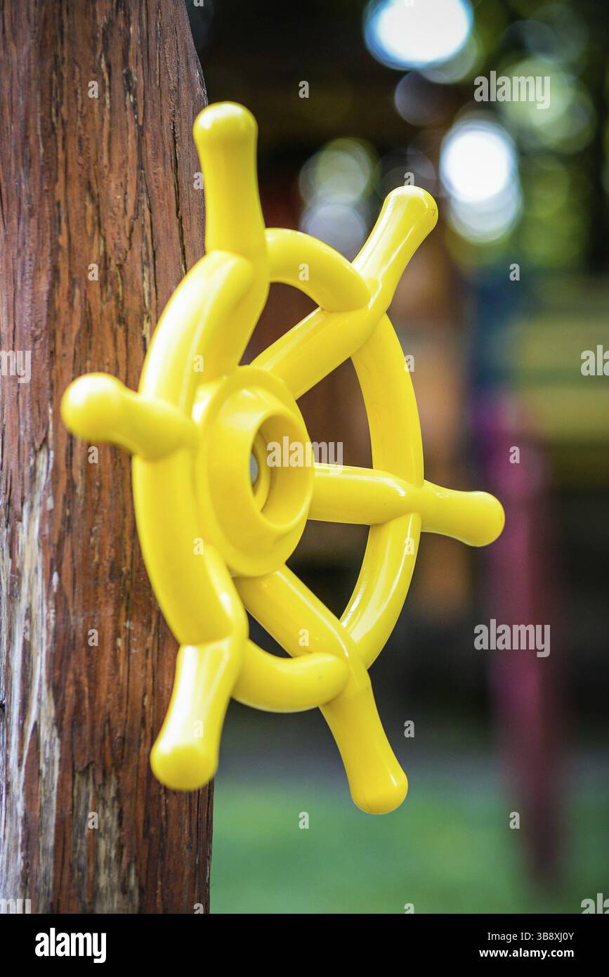 Yellow plastic children's handlebar of the ship a wooden girder on the ...