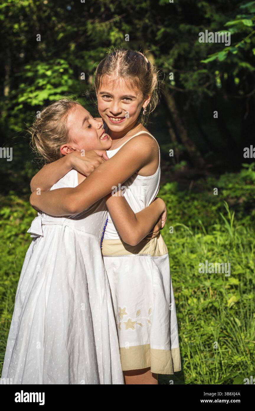 Two beautiful daughters hugging and dancing in the park Stock Photo - Alamy