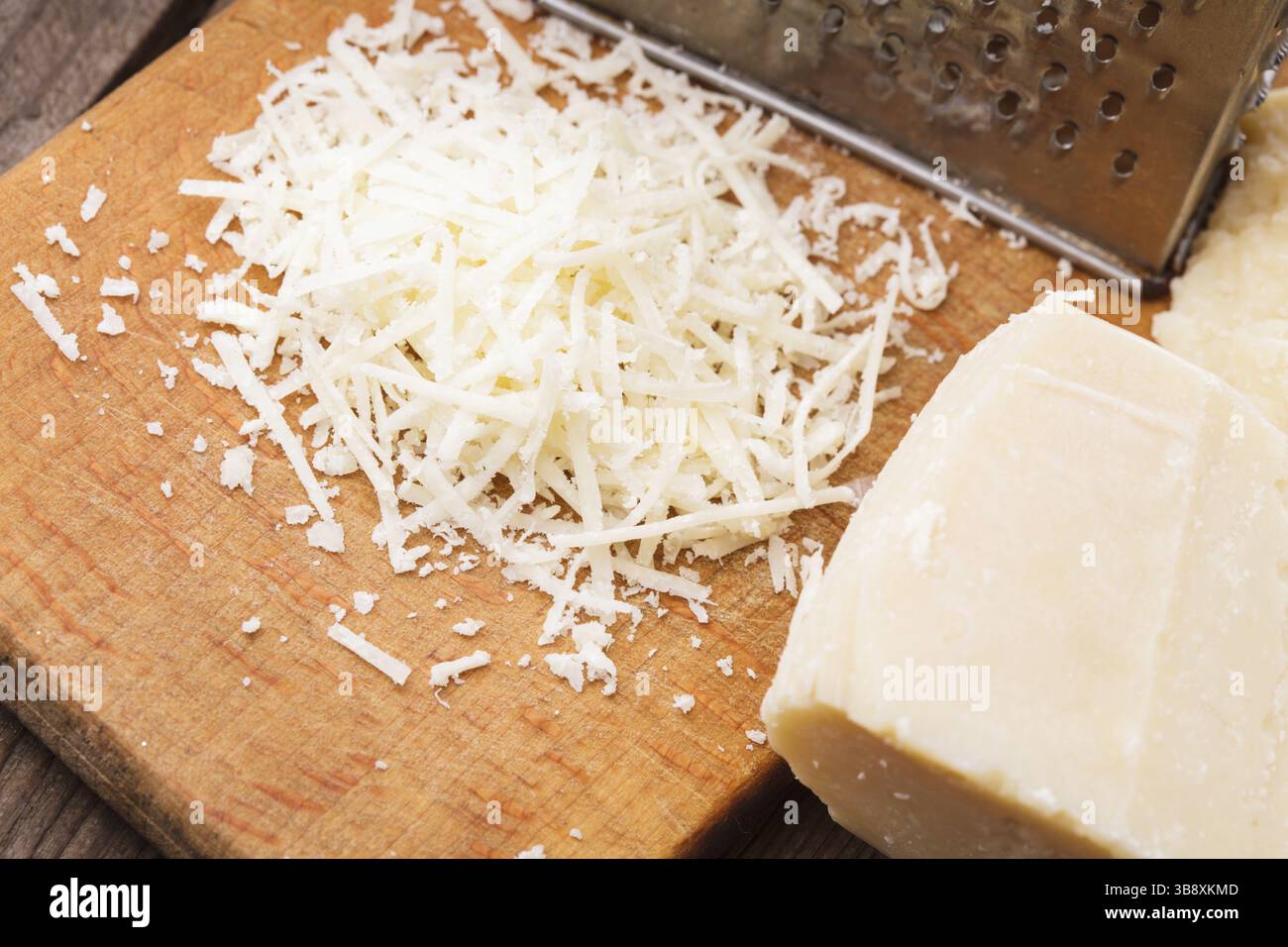 Grated Parmesan cheese with grater on a table Stock Photo - Alamy
