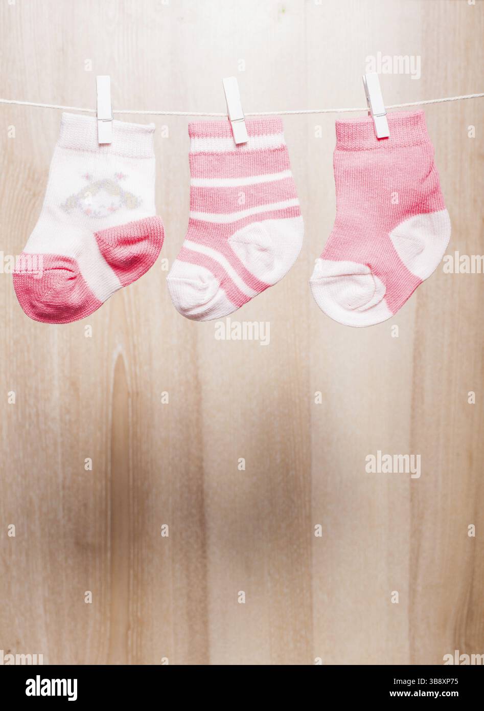 Baby girl socks attached to the rope Stock Photo - Alamy