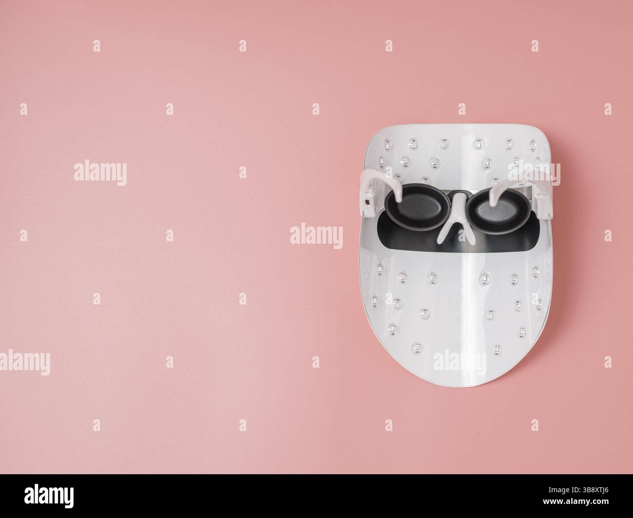 Led light therapy facial mask on pink background. Home skincare and me ...