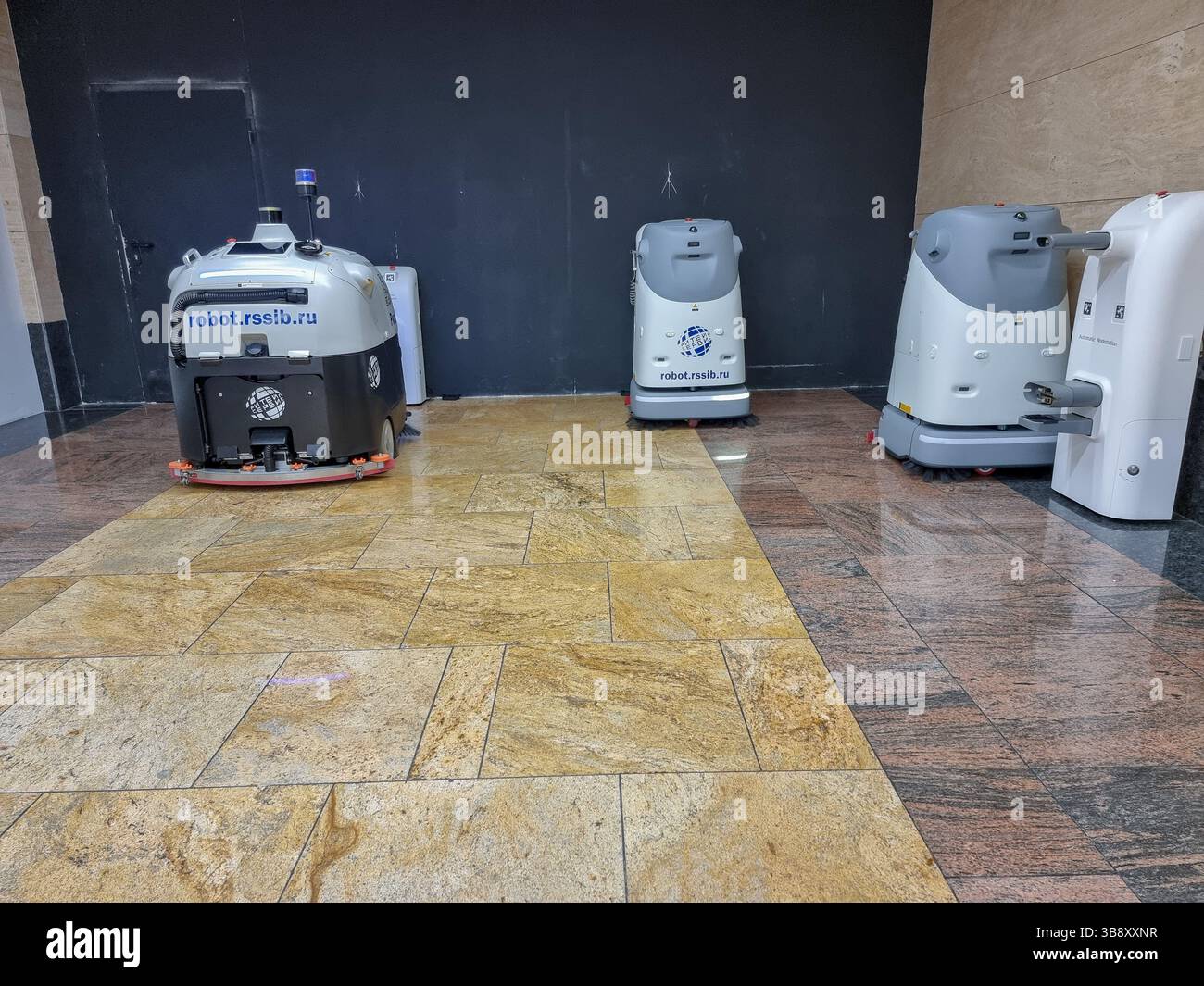 Various self-driving cleaning robots parked in a shopping mall; mop ...