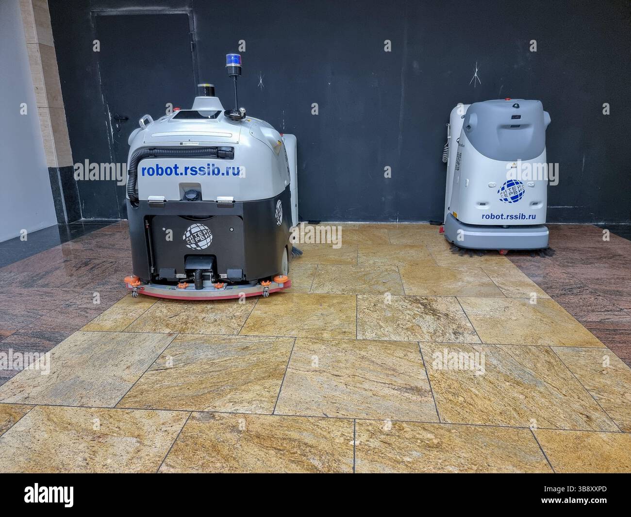 Various self-driving cleaning robots parked in a shopping mall; mop robots, autonomous vehicles ...