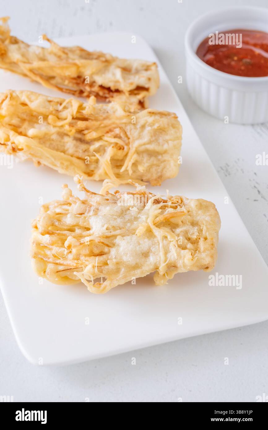 Golden enoki clusters deep-fried to crunch perfection beside sweet ...
