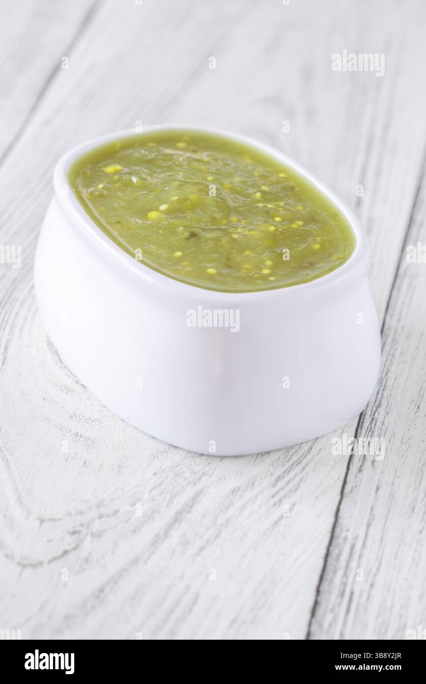Bright green salsa verde swirled into bowl, tangy flavor with smooth ...