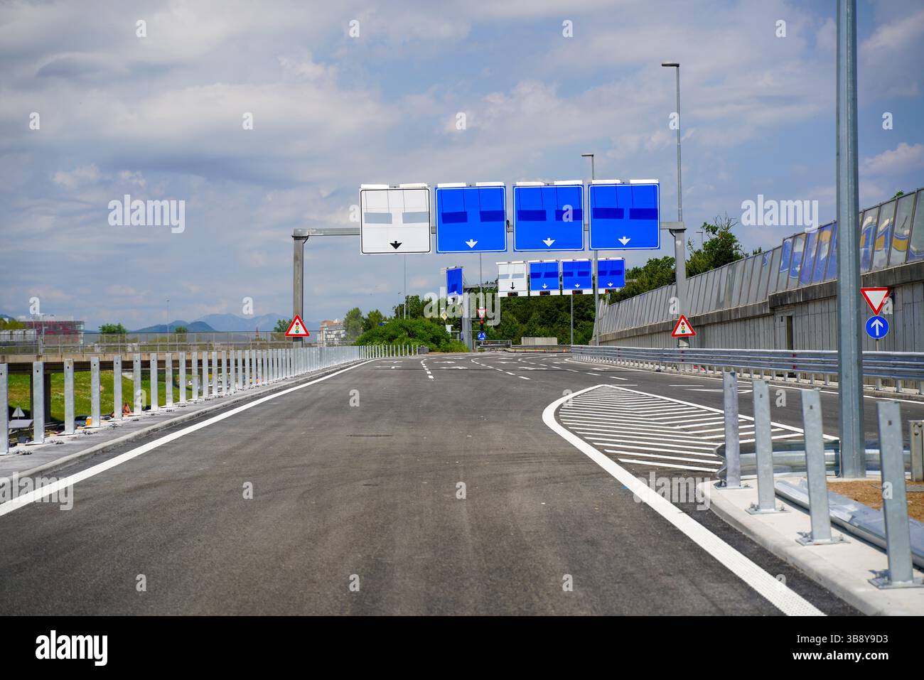 New Highway Ramp with Fresh Asphalt and Traffic Signs in Background ...