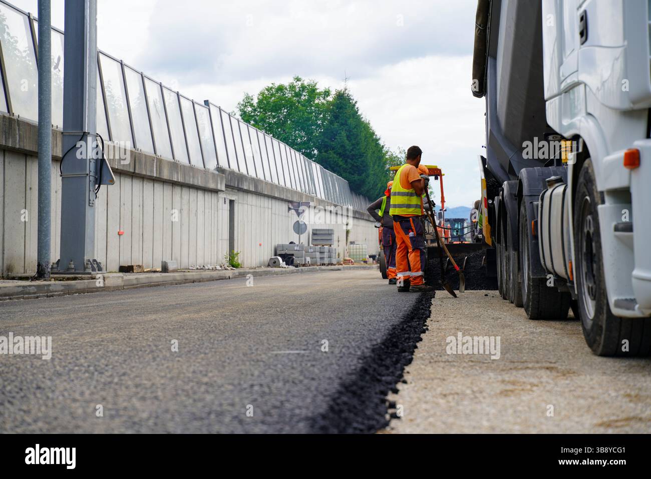 New Fresh Layer of Asphalt Being Laid with Construction Worker, Dump ...
