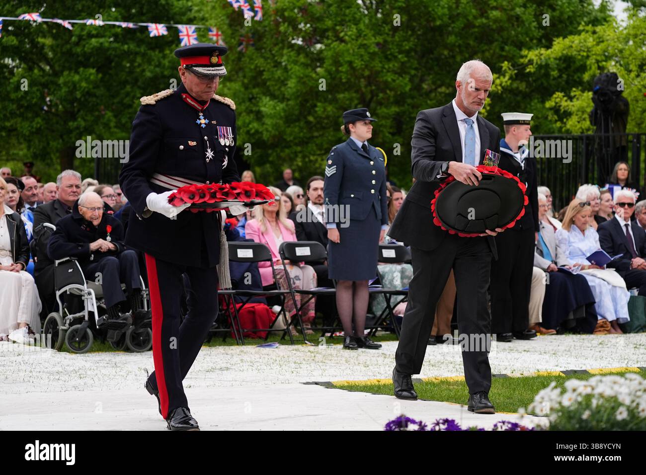 Minister for Veterans and People Alistair Carns (R) lays a wreath ...
