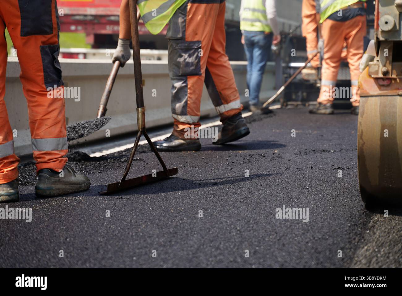 Low-angle shot of multiple construction workers’ legs using tools to ...