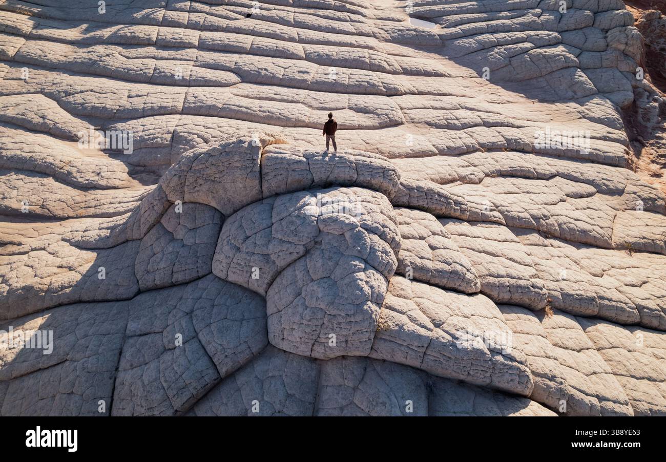 Aerial of a man hiking white Pocket at Vermillion Cliffs in Northern ...