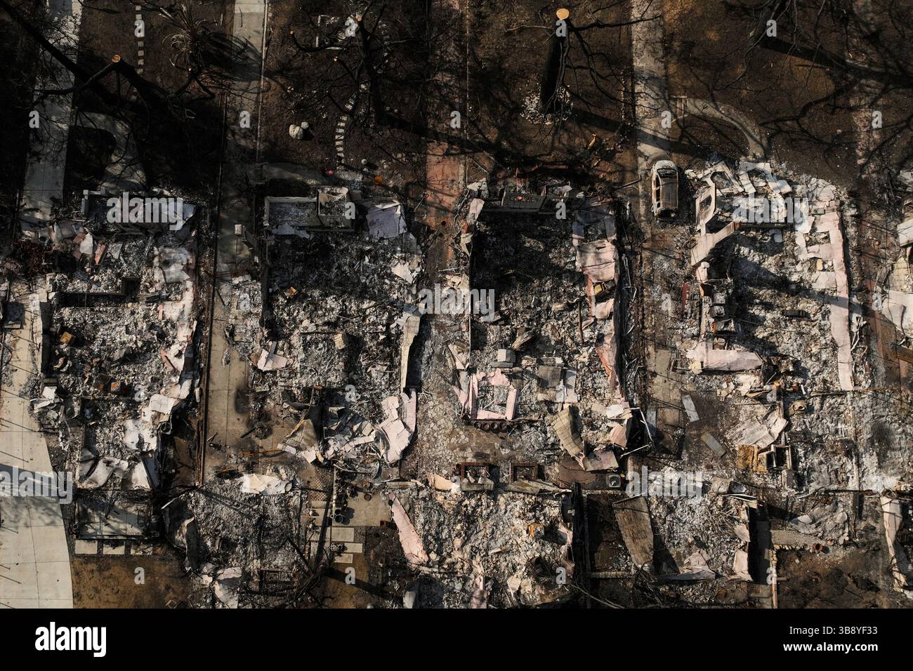 FILE - An aerial photo shows the charred homes of Louise Hamlin, center ...