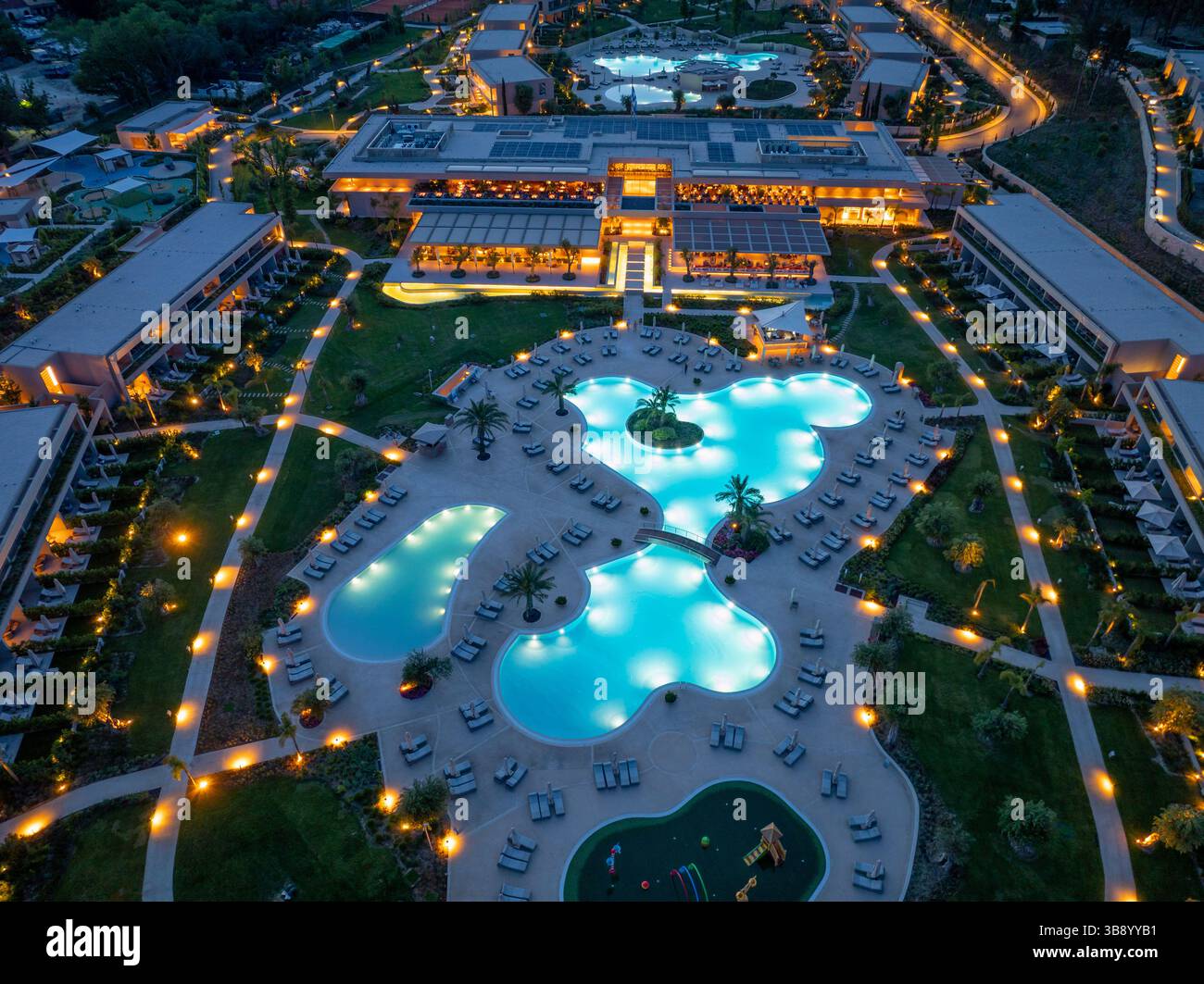 Aerial view of a large luxury hotel complex featuring pools, lush ...