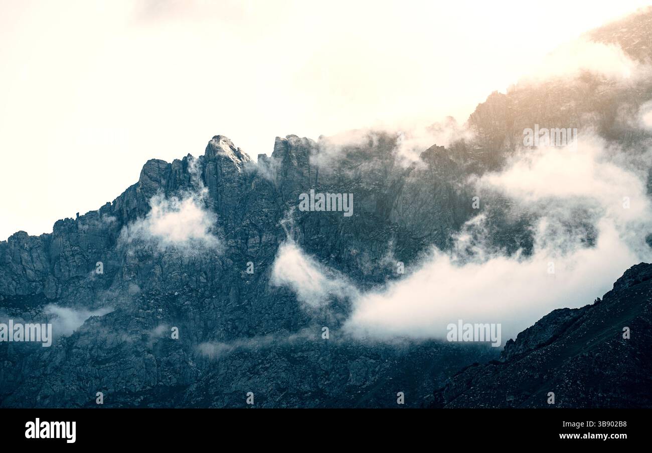 Majestic mountain peaks covered with dramatic mist and sunrise light ...
