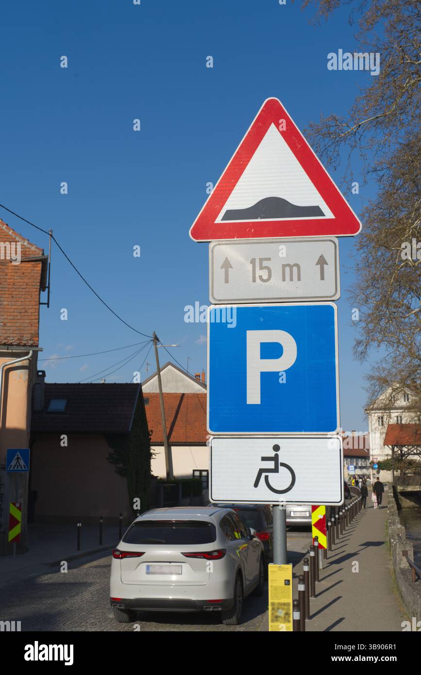 A road sign warns of a speed bump 15 meters ahead, alongside a parking ...