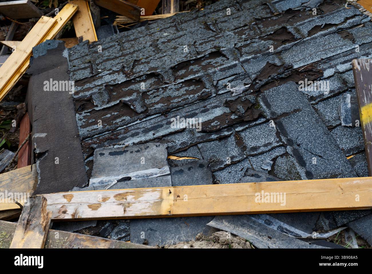 Peeling, worn asphalt shingles reveal a deteriorating roof surface ...