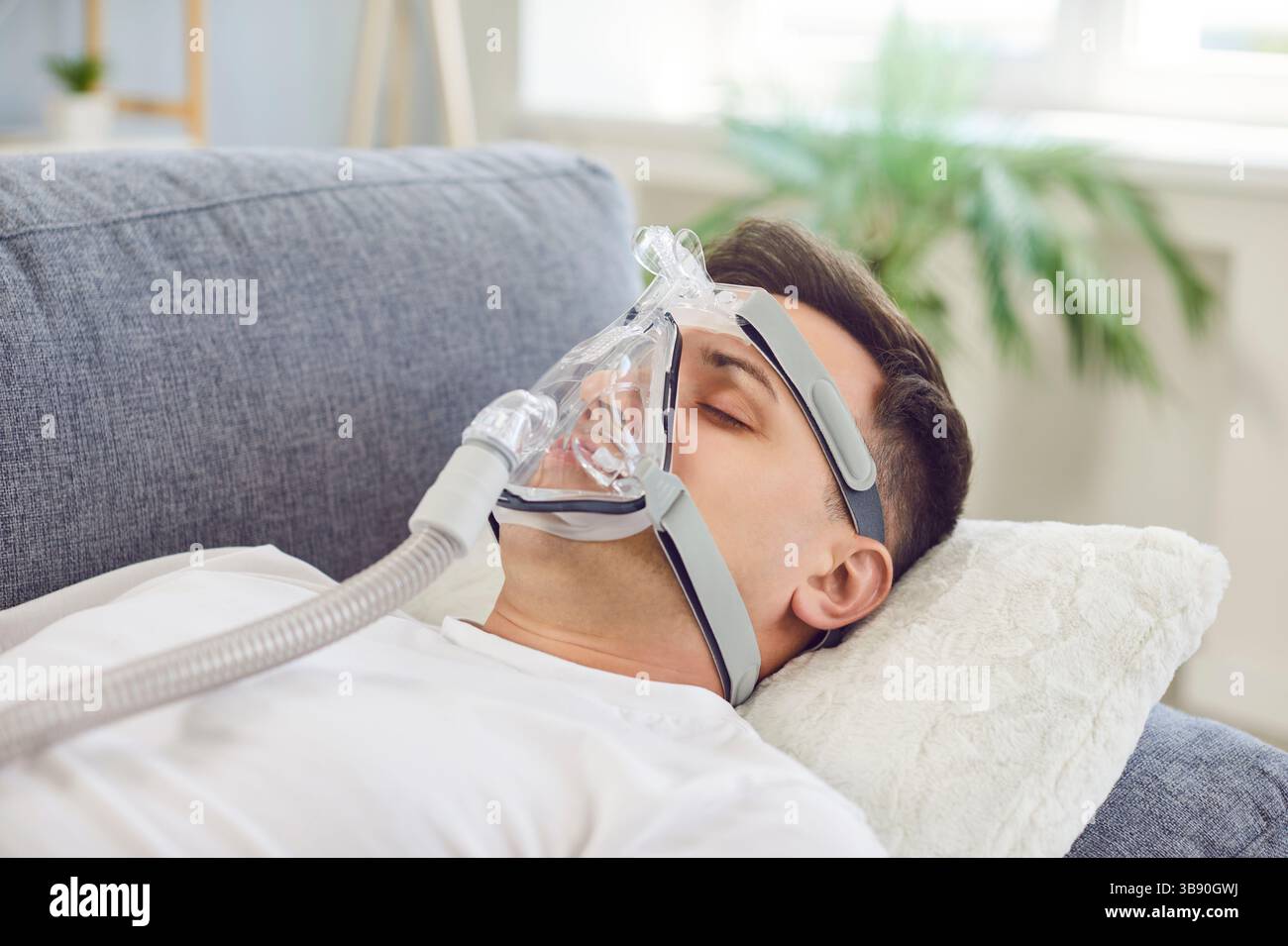 Portrait of a young male unconscious person lying on sofa with oxygen ...
