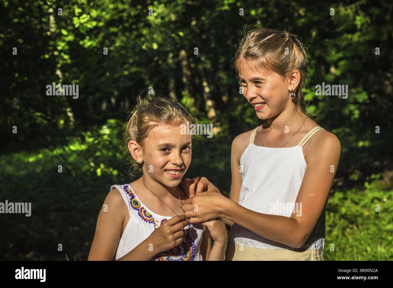 Two beautiful daughters hugging and dancing in the park Stock Photo - Alamy