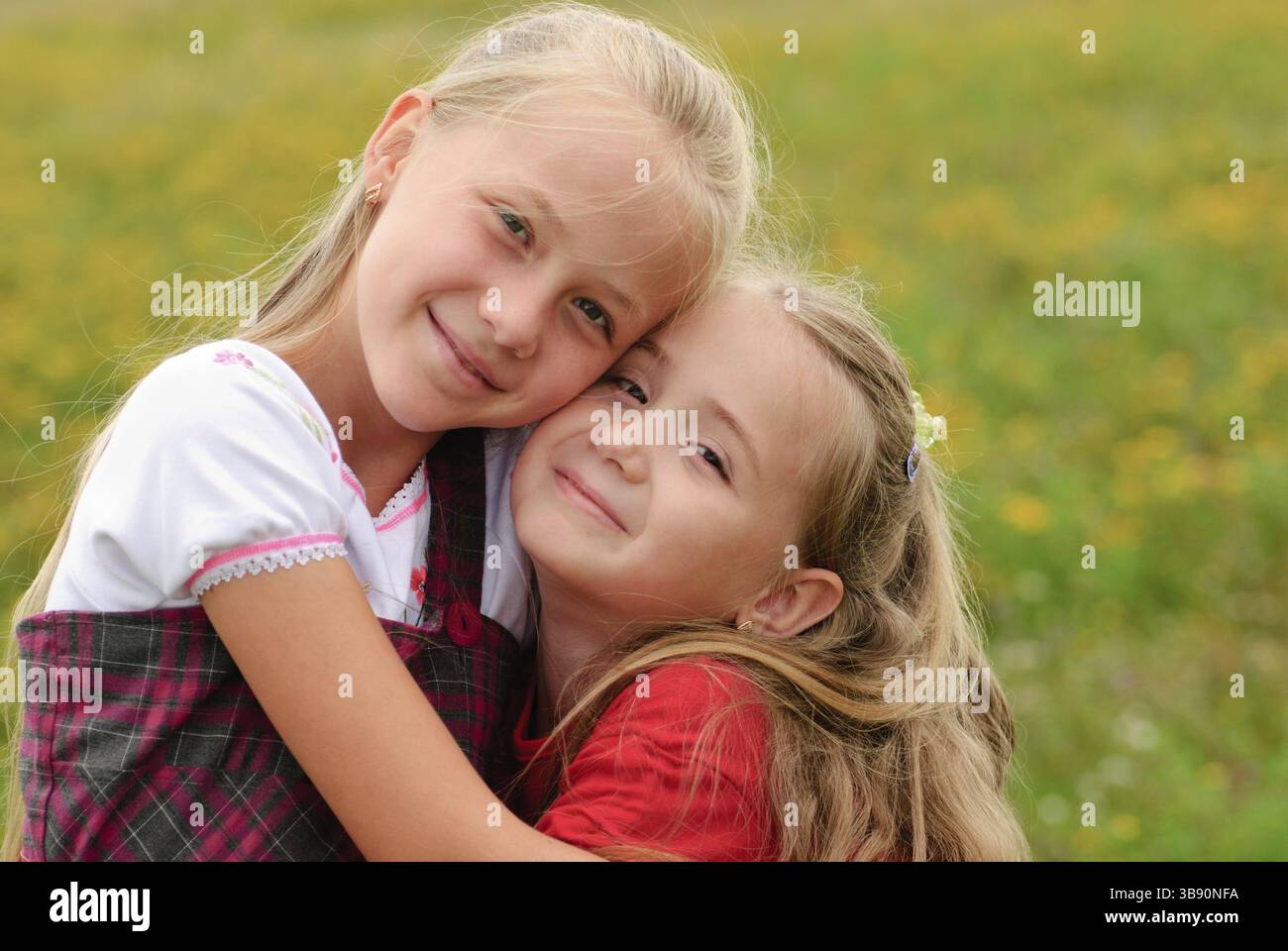 Two sisters hug one another outdoors, happy family Stock Photo - Alamy