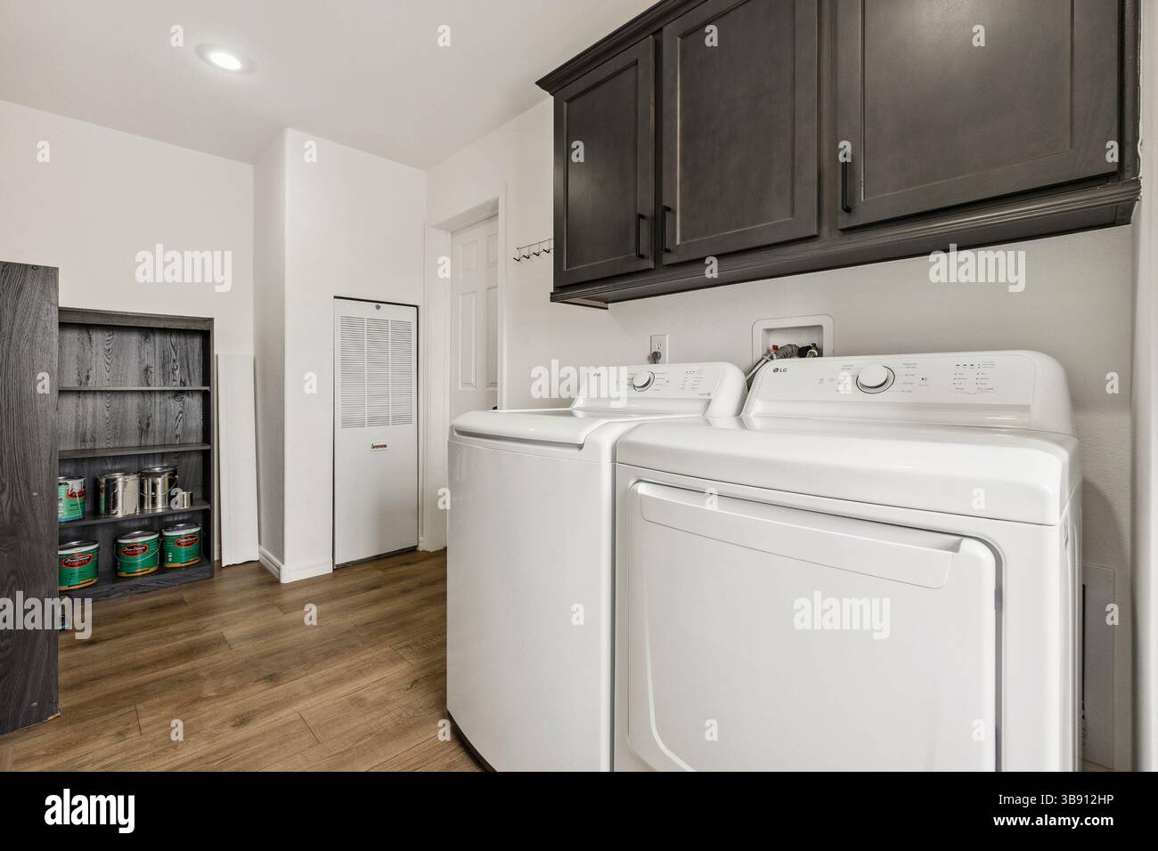 The laundry room features a modern washer and dryer, complemented by ...