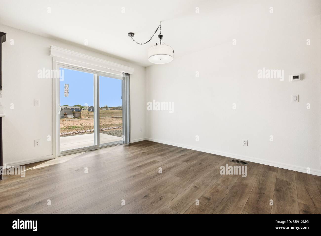 The living room appears completely empty, featuring beautiful hardwood ...