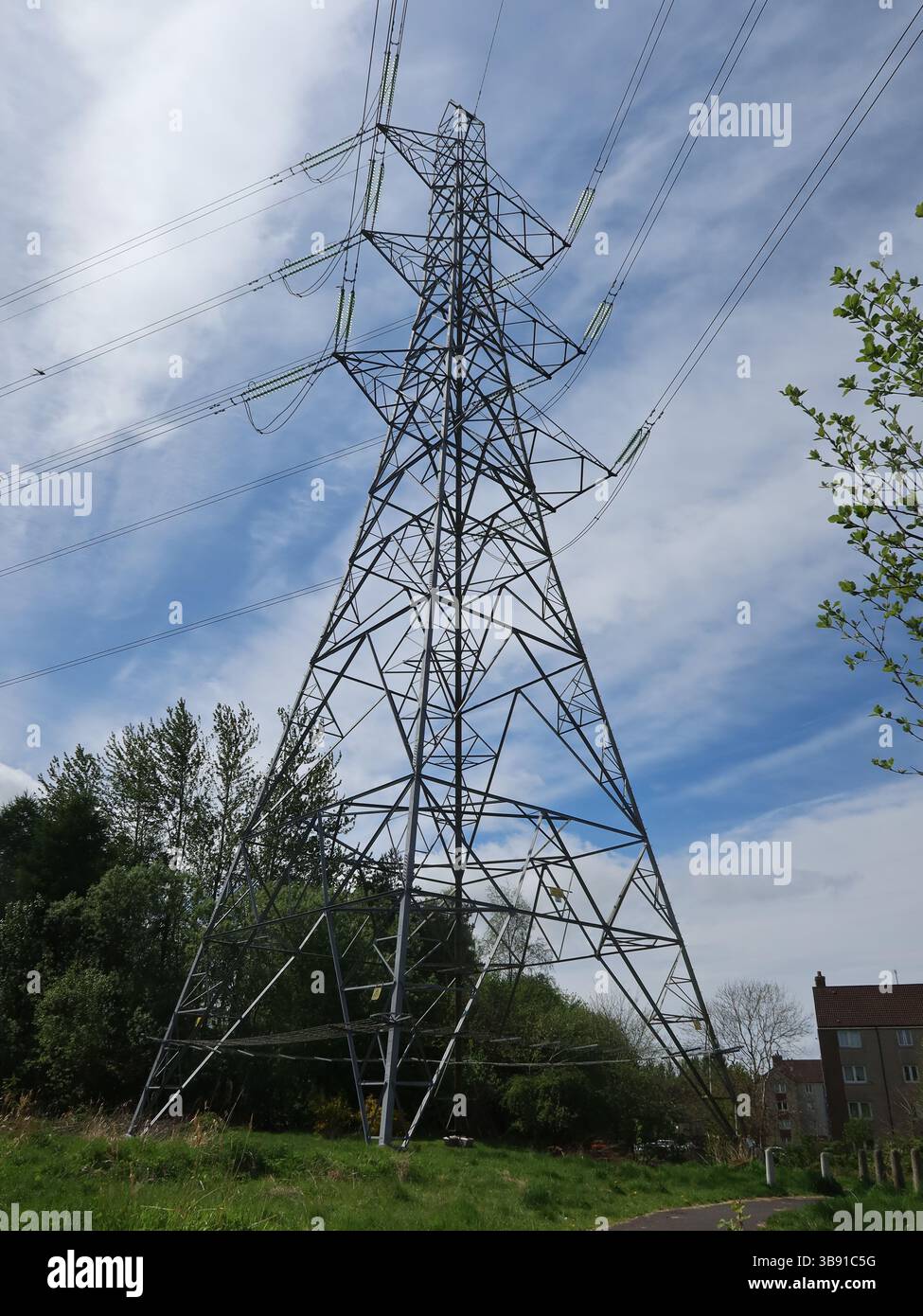 A towering electricity pylon holding up the high-voltage overhead power ...