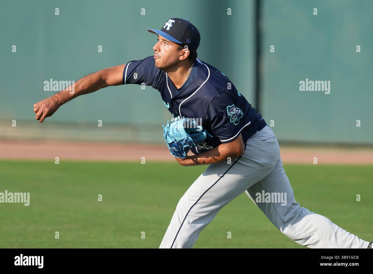 Starting pitcher Alain Pena (28) of the Asheville Tourists warms up ...