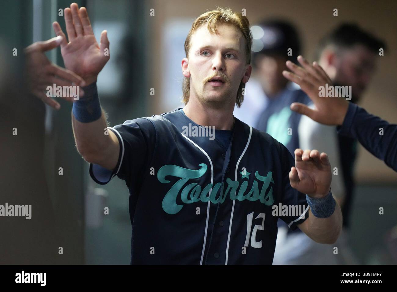 Walker Janek (12) of the Asheville Tourists is greeted in the dugout ...