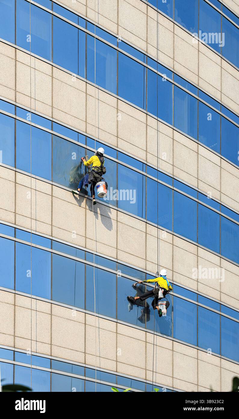 high rise building Window washers cleaning the glass facade of a modern ...