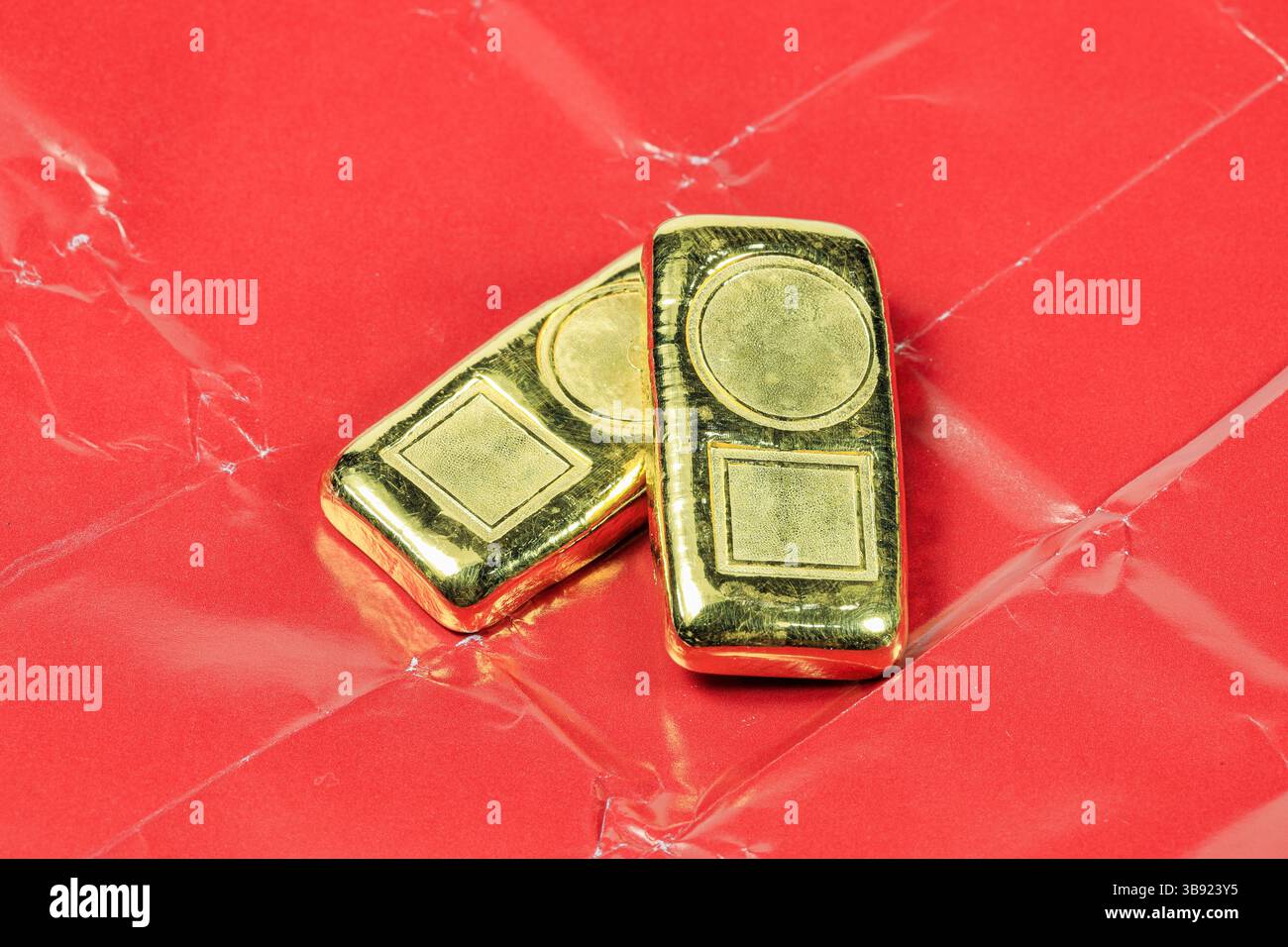 A stack of real shiny gold bars or gold ingots On the red paper used to ...