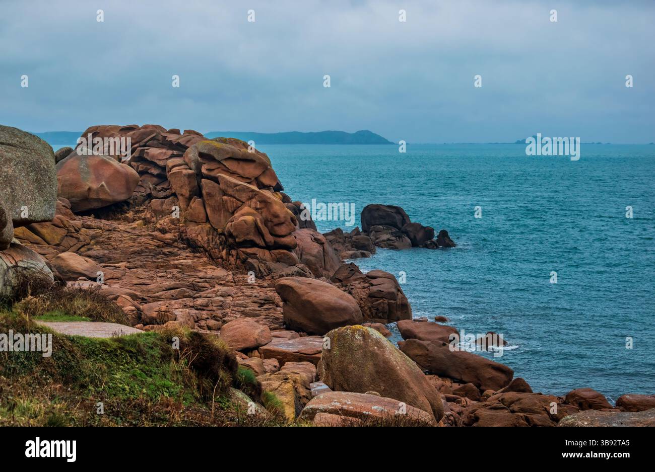 Rugged shoreline with red granite rock formations and turquoise sea ...