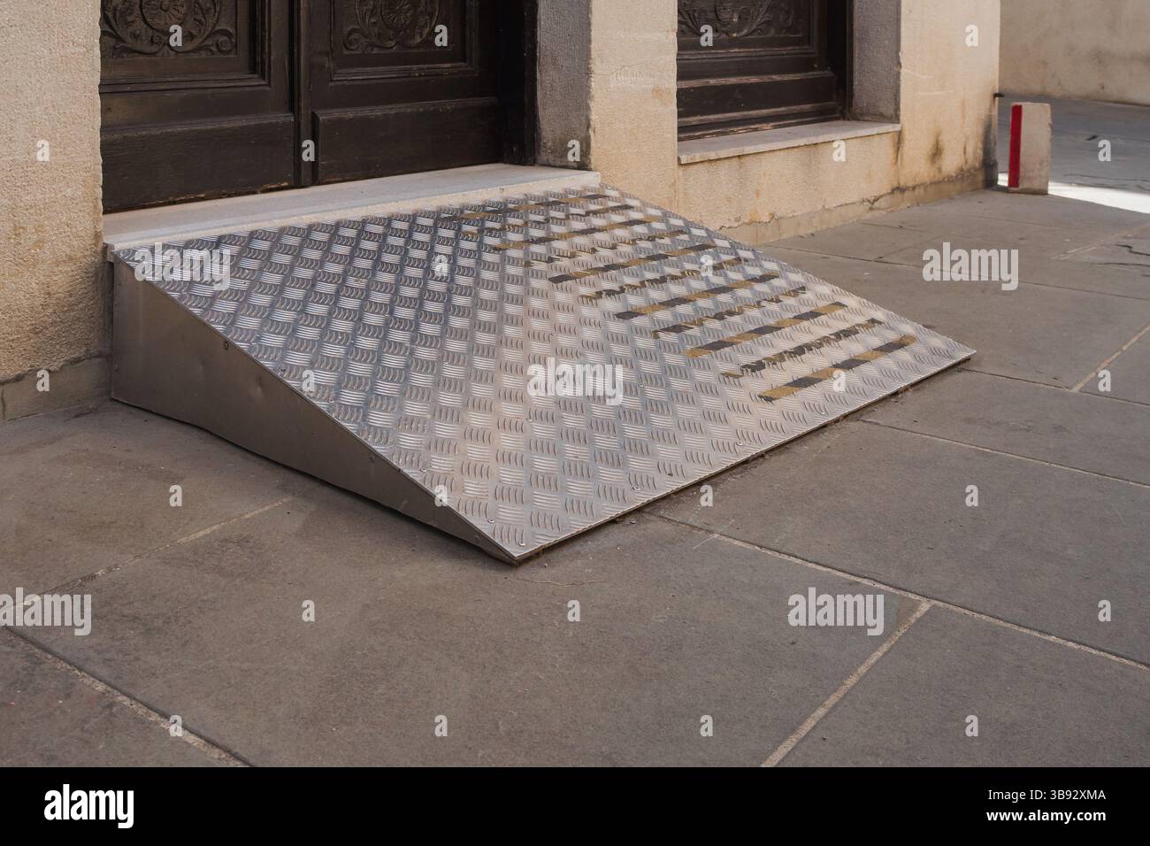 Accessible building entrance with ramp for wheelchair users and people ...
