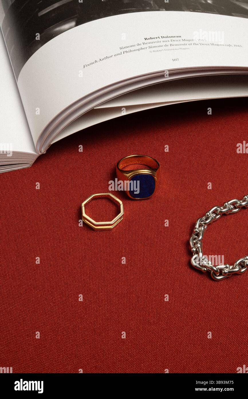 Men's Gold Rings and Silver Chain Bracelet with Art Book on Red Fabric ...