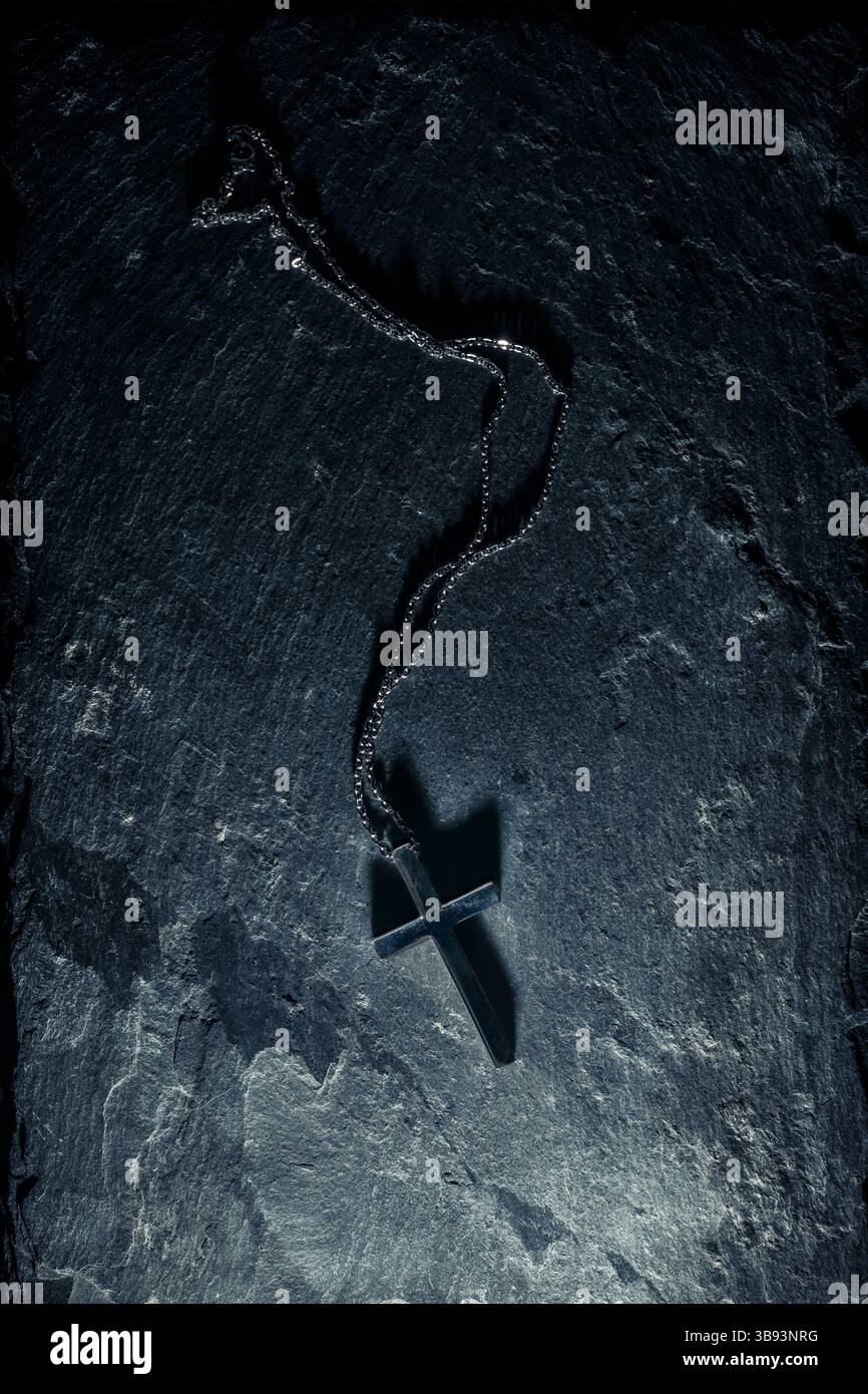 Christian cross necklace on slate background with the crucifix casting ...