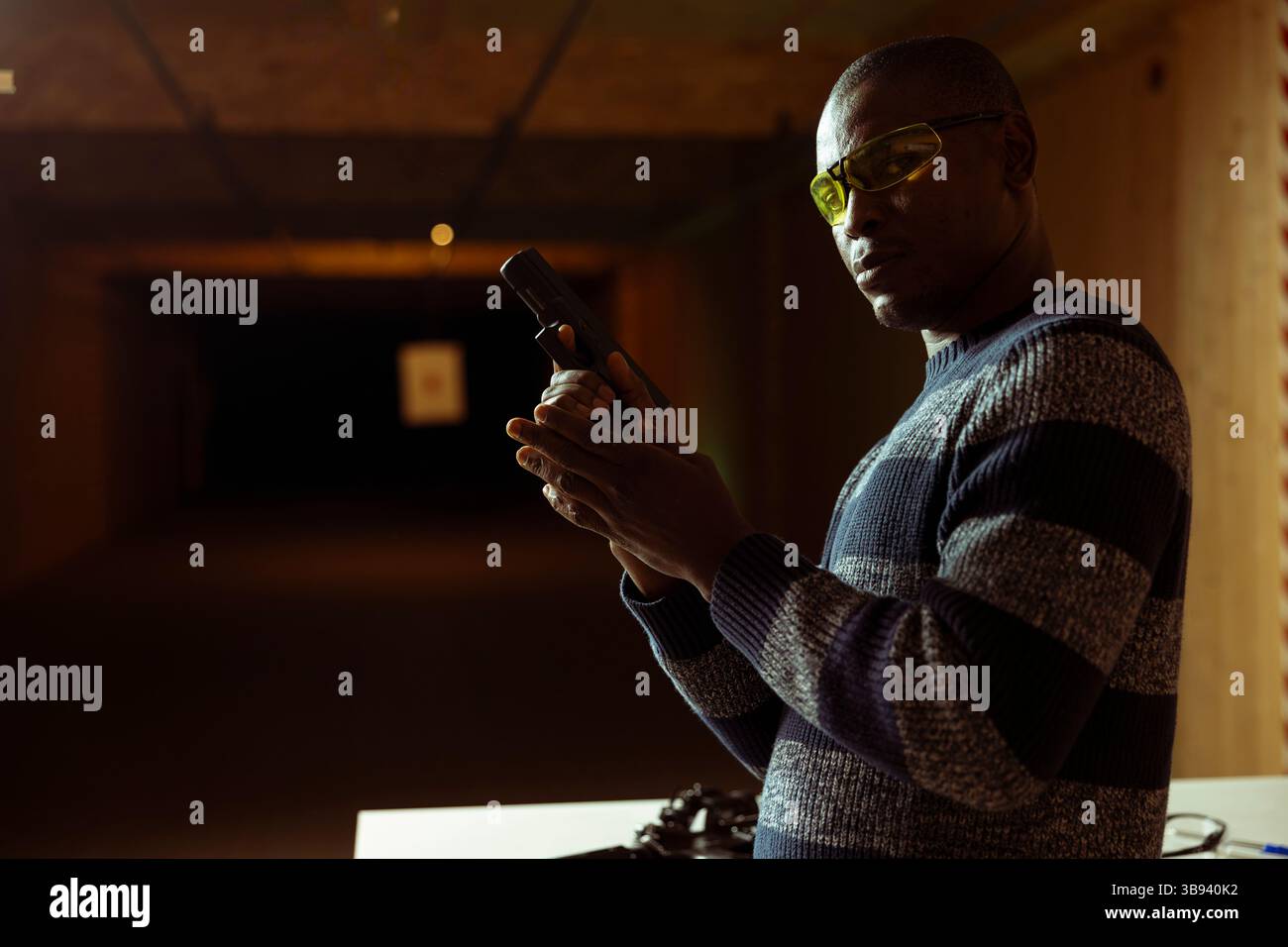 Portrait of man in shooting range trying out new gun model before ...
