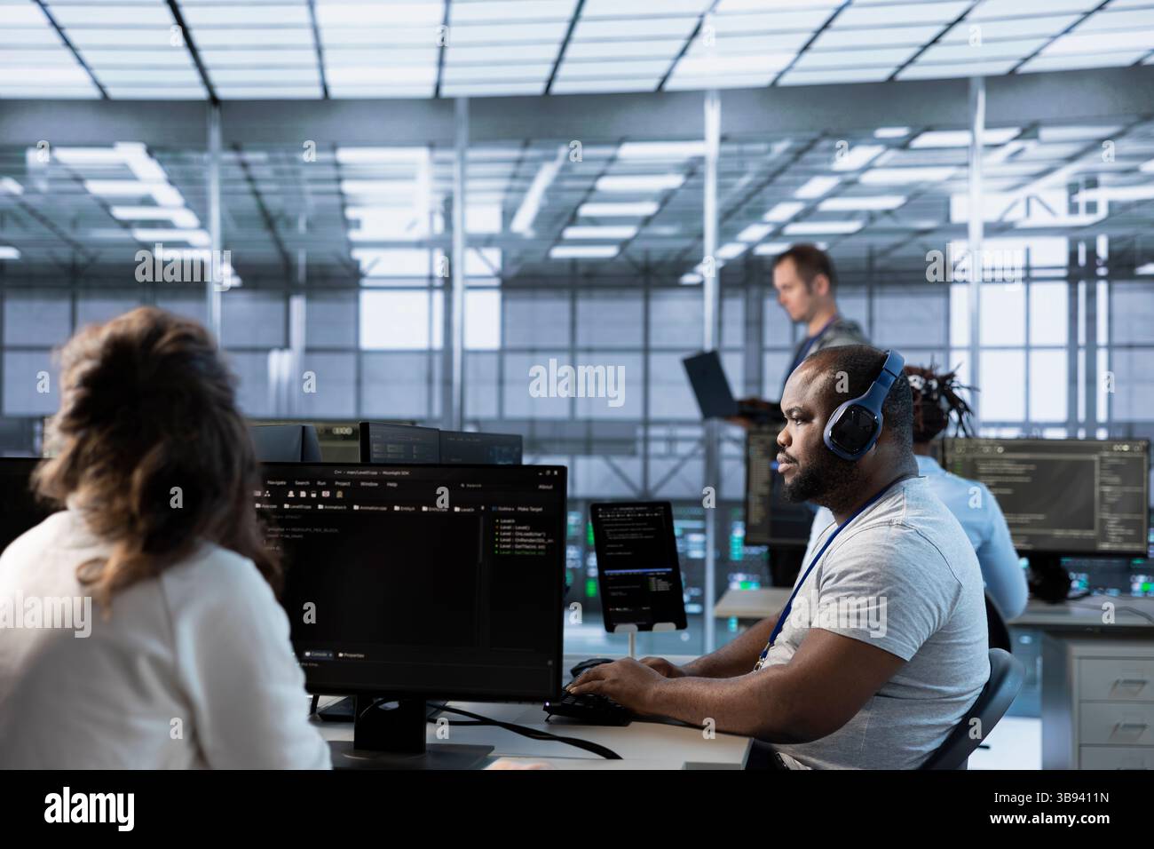 African american man in data center coordinating deployment of server architecture, improving ...