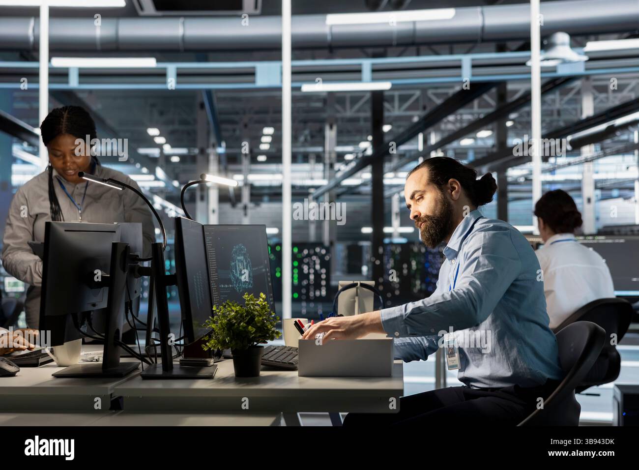 Upset engineer in data center packing personal items at workstation ...