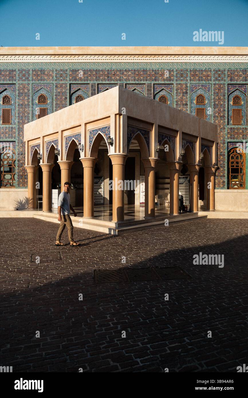 A man walking in front of the beautiful Katara Mosque in Katara ...