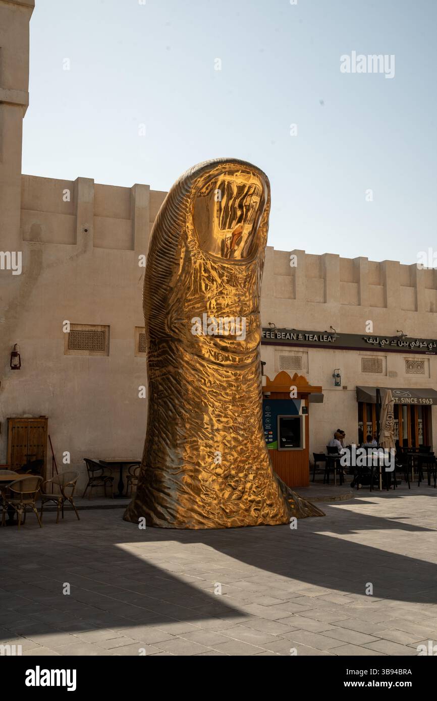 The iconic Golden Thumb statue at Souq Waqif in Doha, Qatar, standing ...