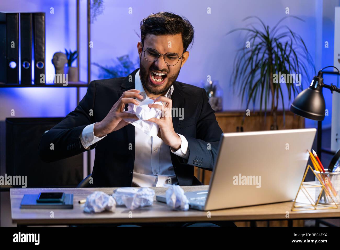 Angry furious Indian man working at office throwing crumpled paper ...