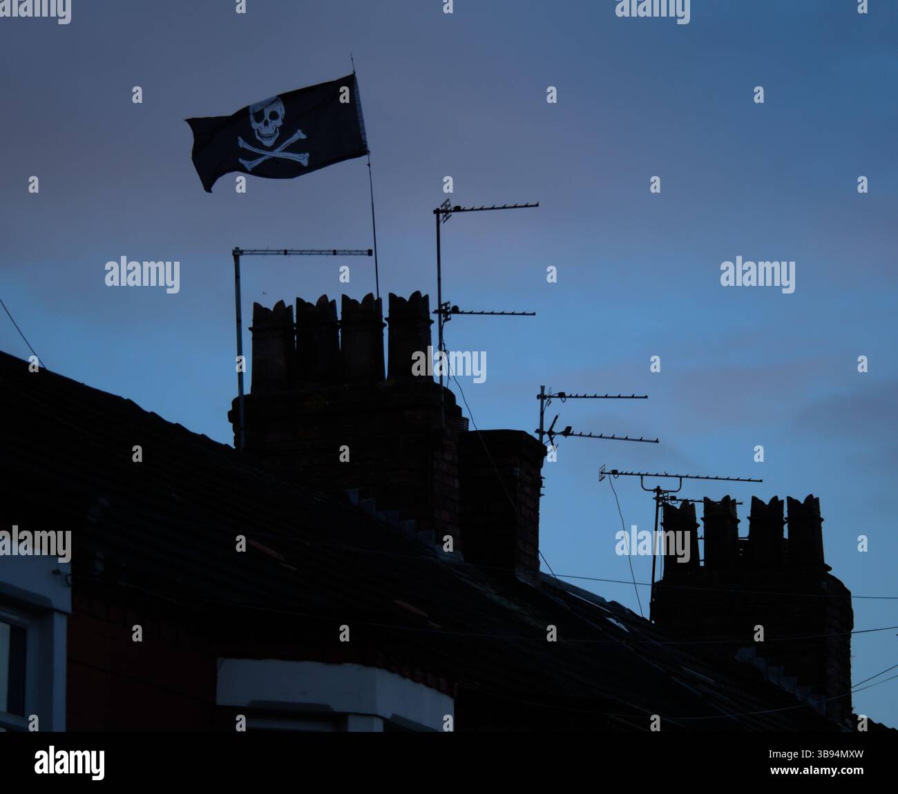 Jolly Roger flying off a terrace roof with TV aerials Stock Photo - Alamy